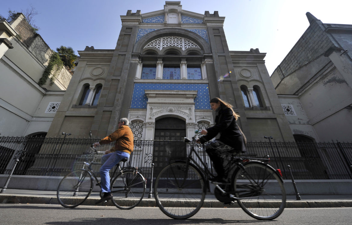 PRINT Two people ride bicycles past synagogue in Milan | RNS