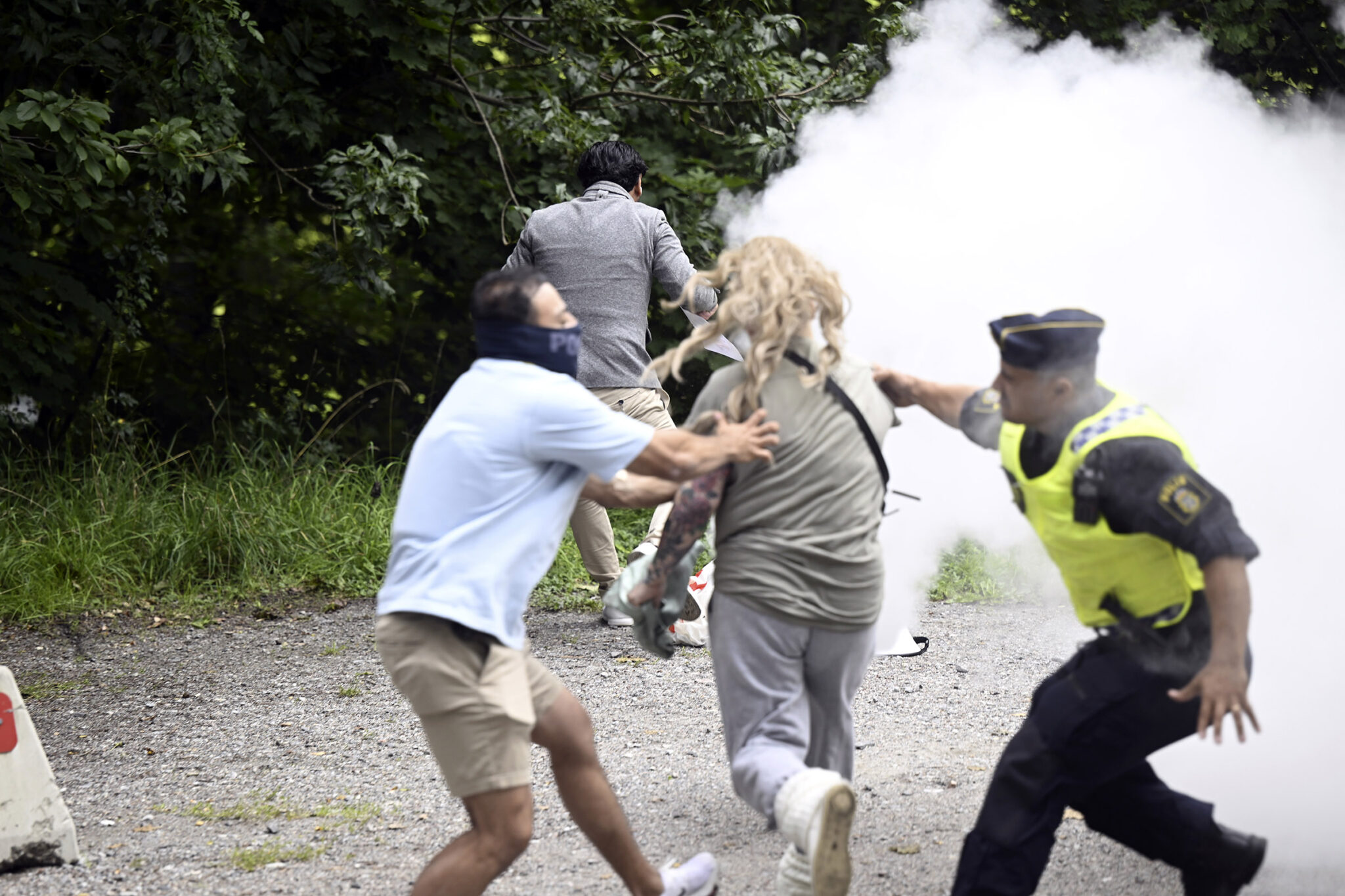 A woman interrupts a Quran-burning protest in Sweden by spraying ...